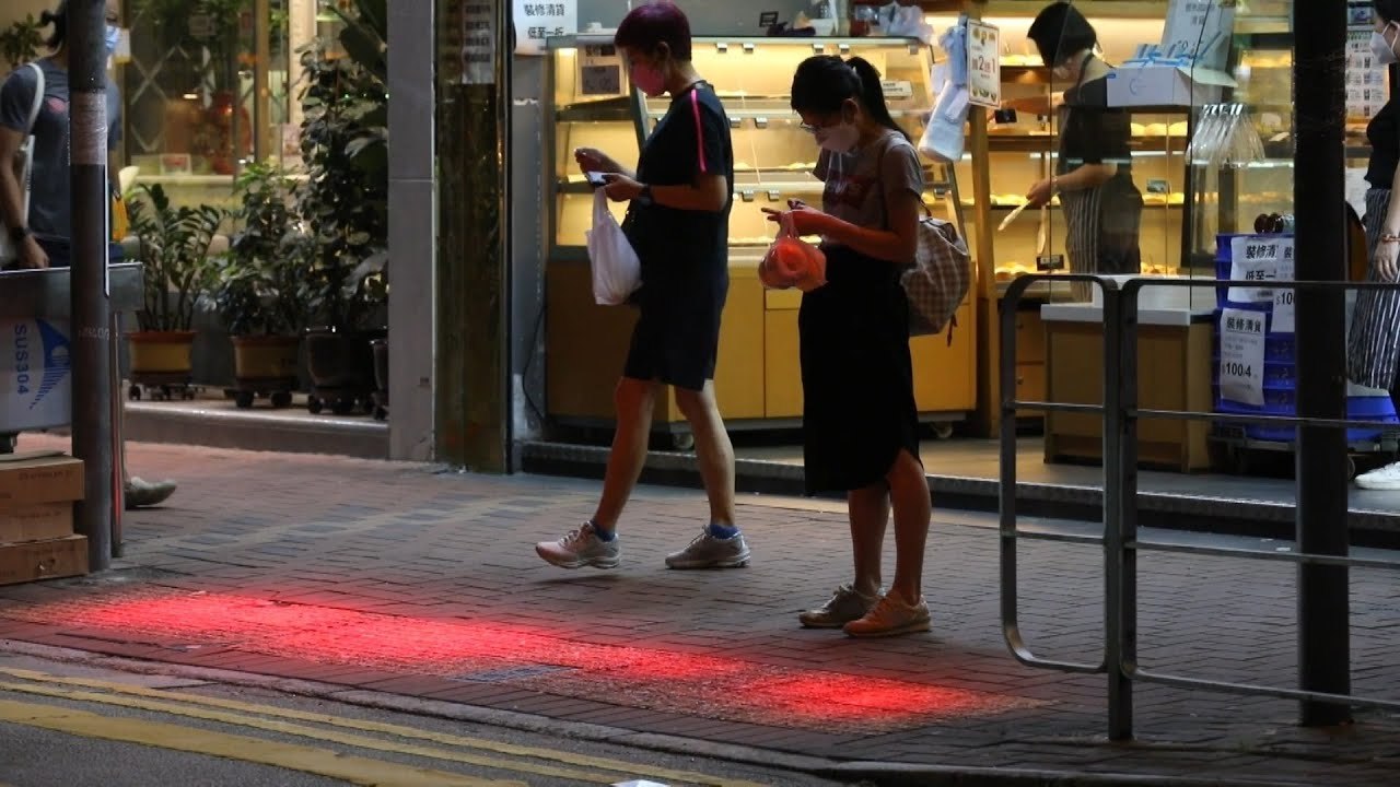 Hong Kong proyecta en la acera luces rojas para 'adictos' al móvil
